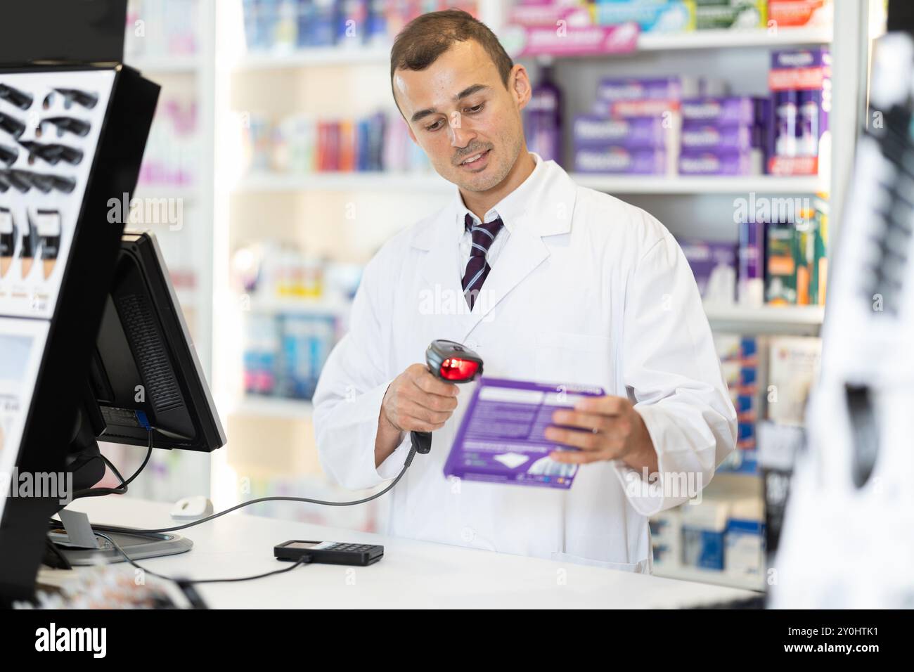 Young male pharmacist scanning barcode on sold medicine box Stock Photo ...