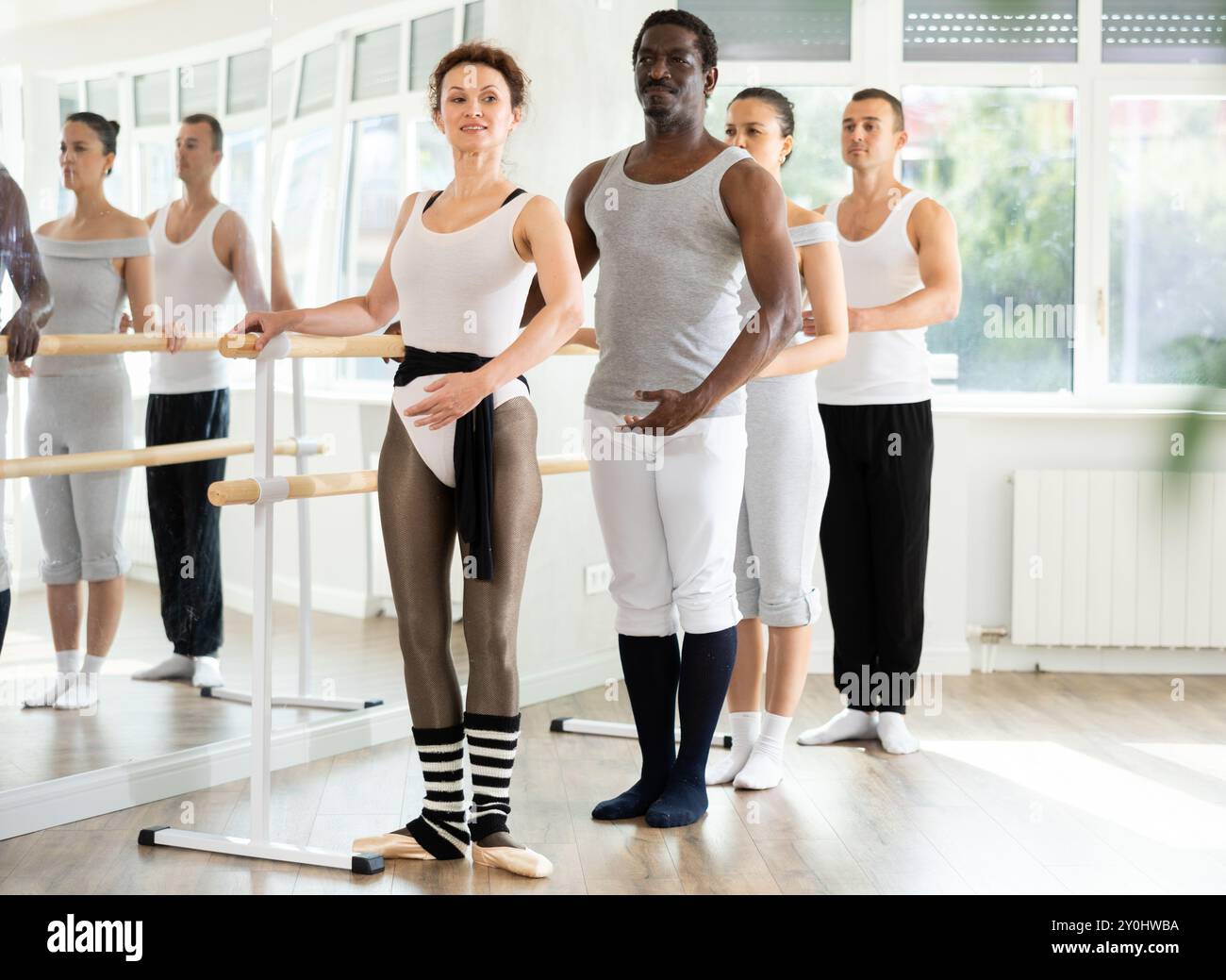 Group of dancers stand in first position at barre Stock Photo - Alamy