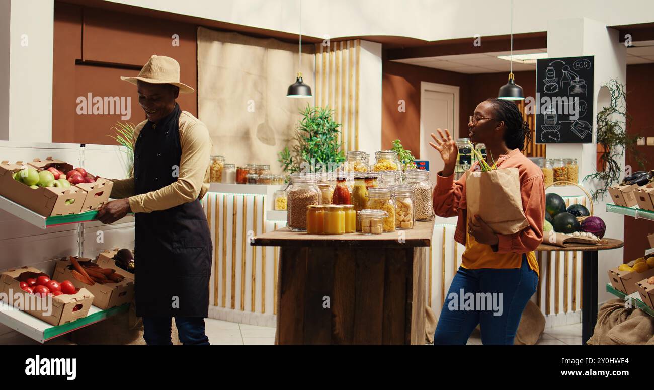 Business owner restocking crates of fresh fruits and vegetables ...