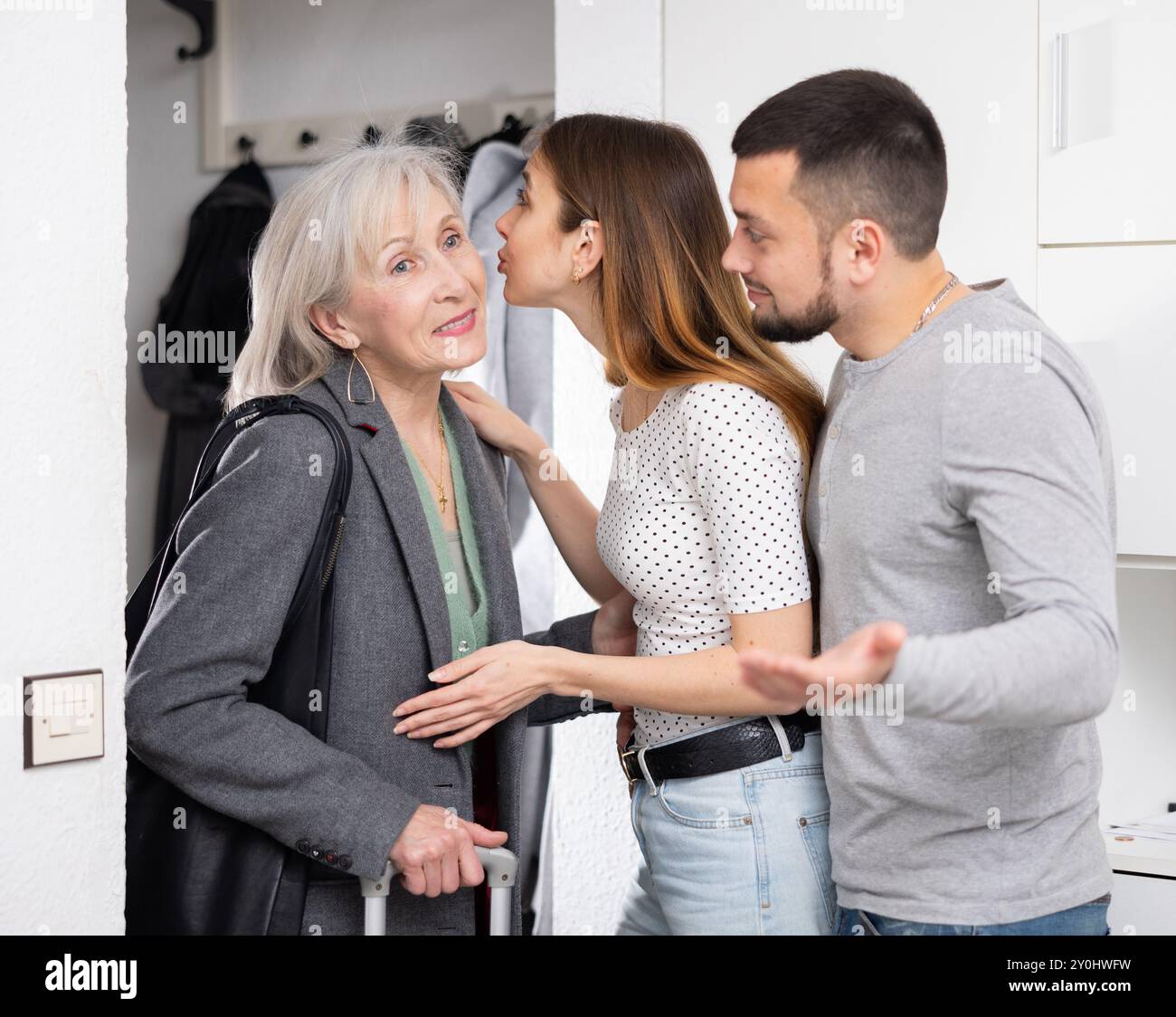 Young family couple seeing off mature woman Stock Photo - Alamy