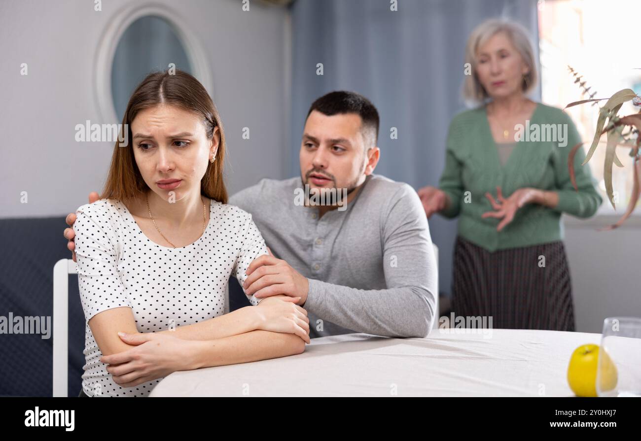 Domestic quarrel - husband and mother try to calm crying wife Stock ...