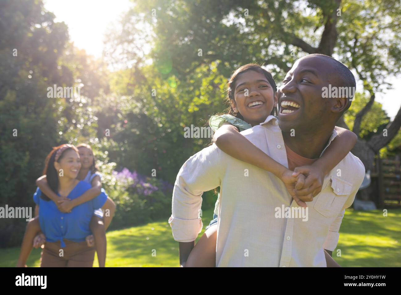 Playing piggyback, happy family enjoying outdoor time together in ...
