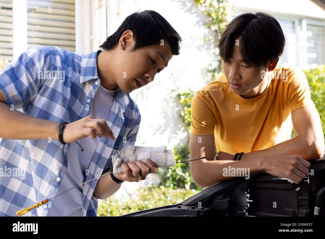 Checking car oil level, father teaching son about car maintenance ... Checking car oil level, father teaching son about car maintenance ...
