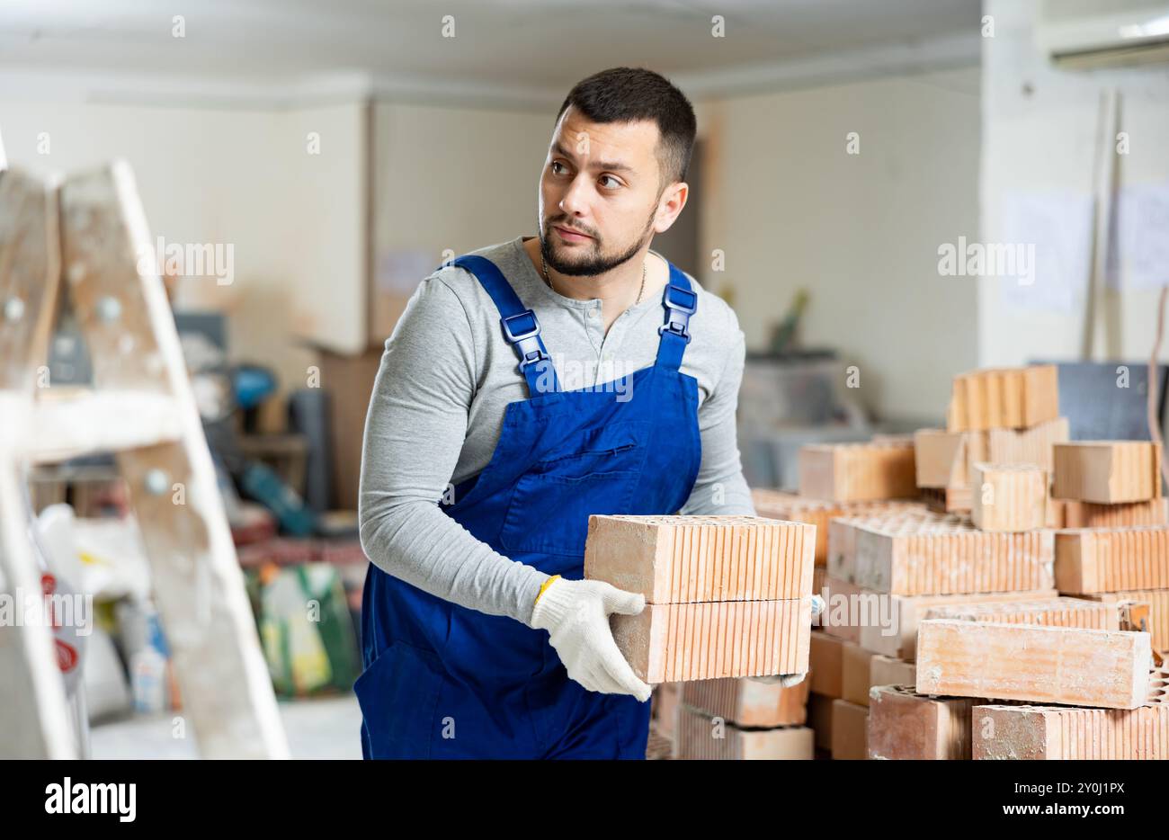 Construction worker carrying bricks at renovating object Stock Photo ...