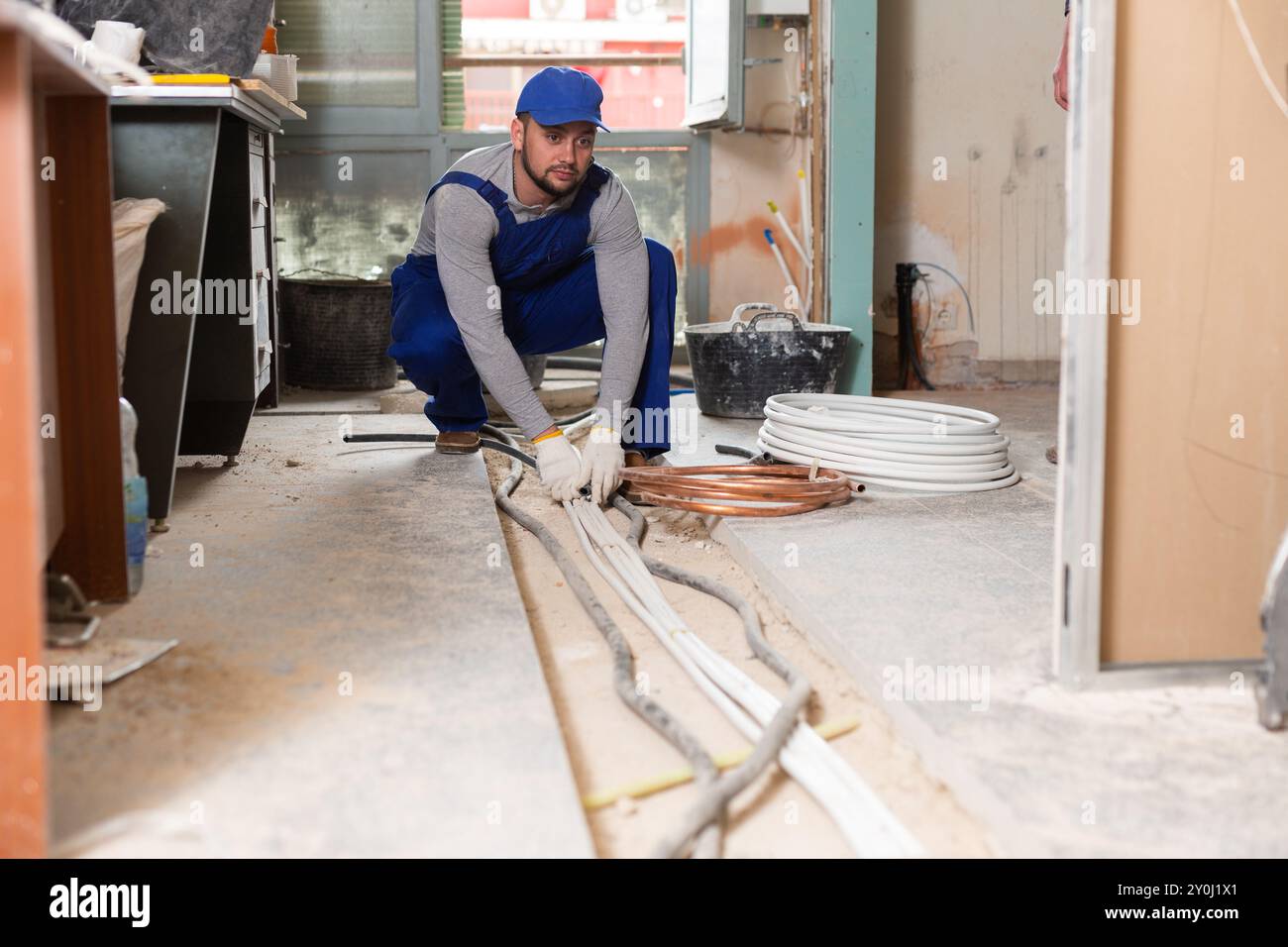 Man electrical installer laying cables through trench Stock Photo - Alamy