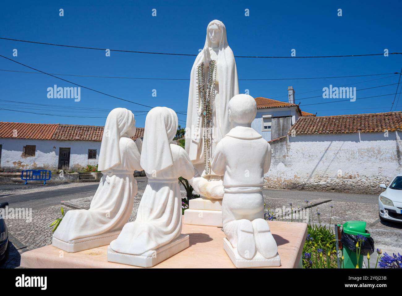 White stone statue of the 3 shepherd children kneeling and praying next ...