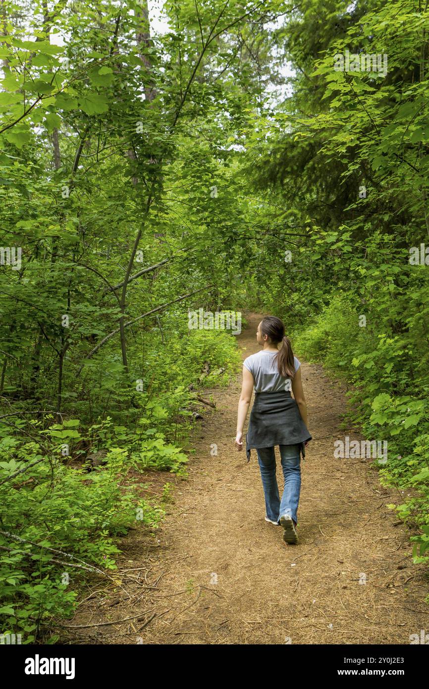 A teen girl takes a stroll through a path in the woods Stock Photo - Alamy