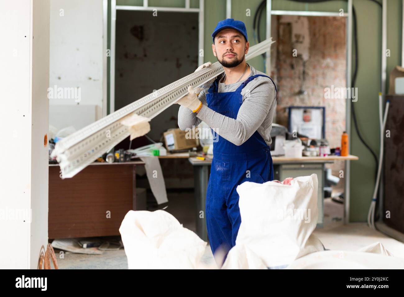 Worker carrying construction materials at renovating object Stock Photo ...