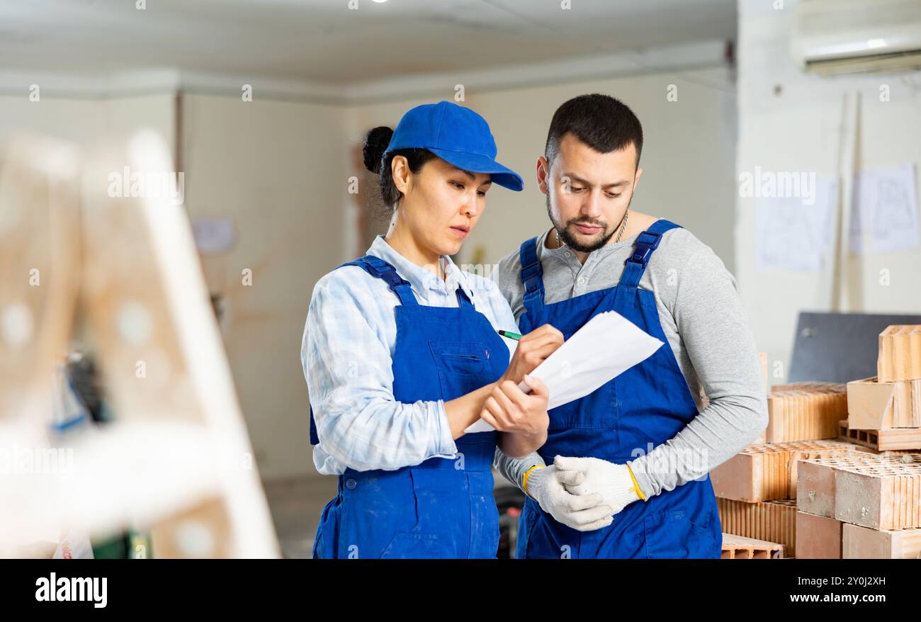 Builders determining scope of work in building under renovation Stock ...