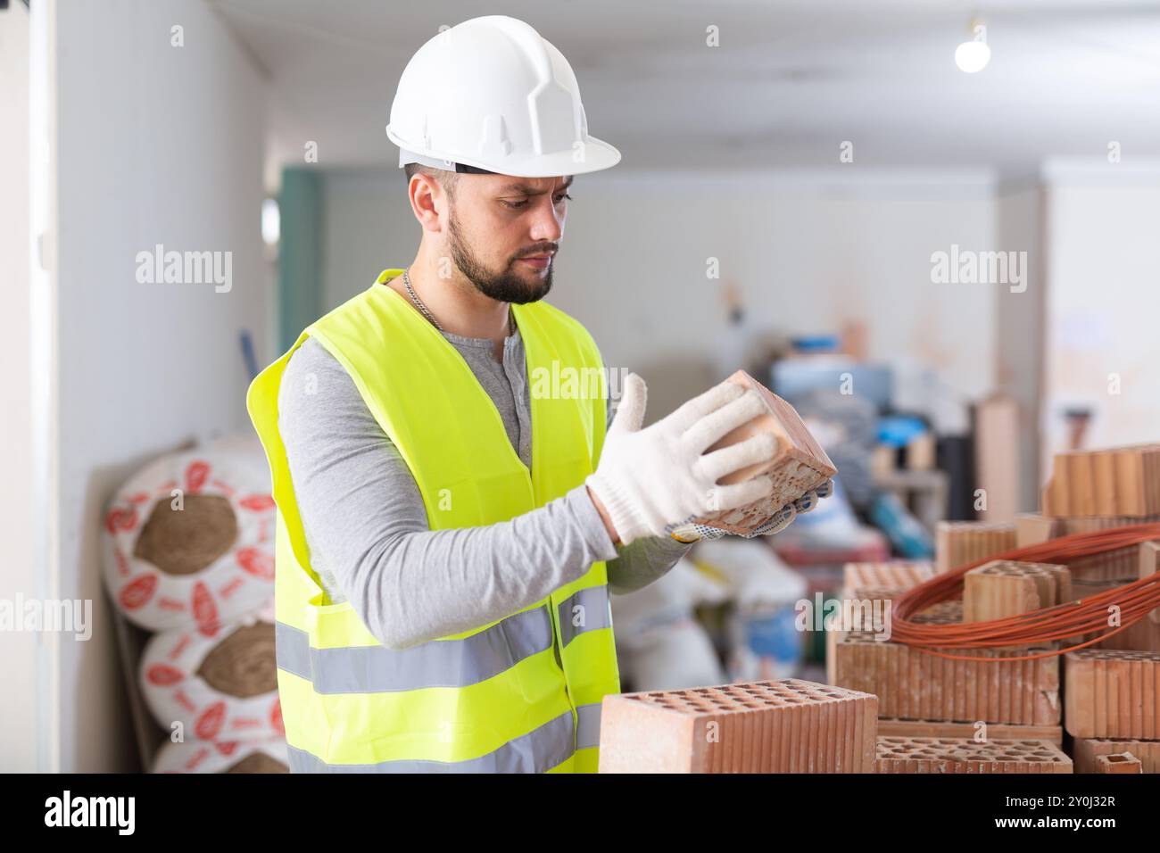 Construction worker checking bricks at renovating object Stock Photo ...