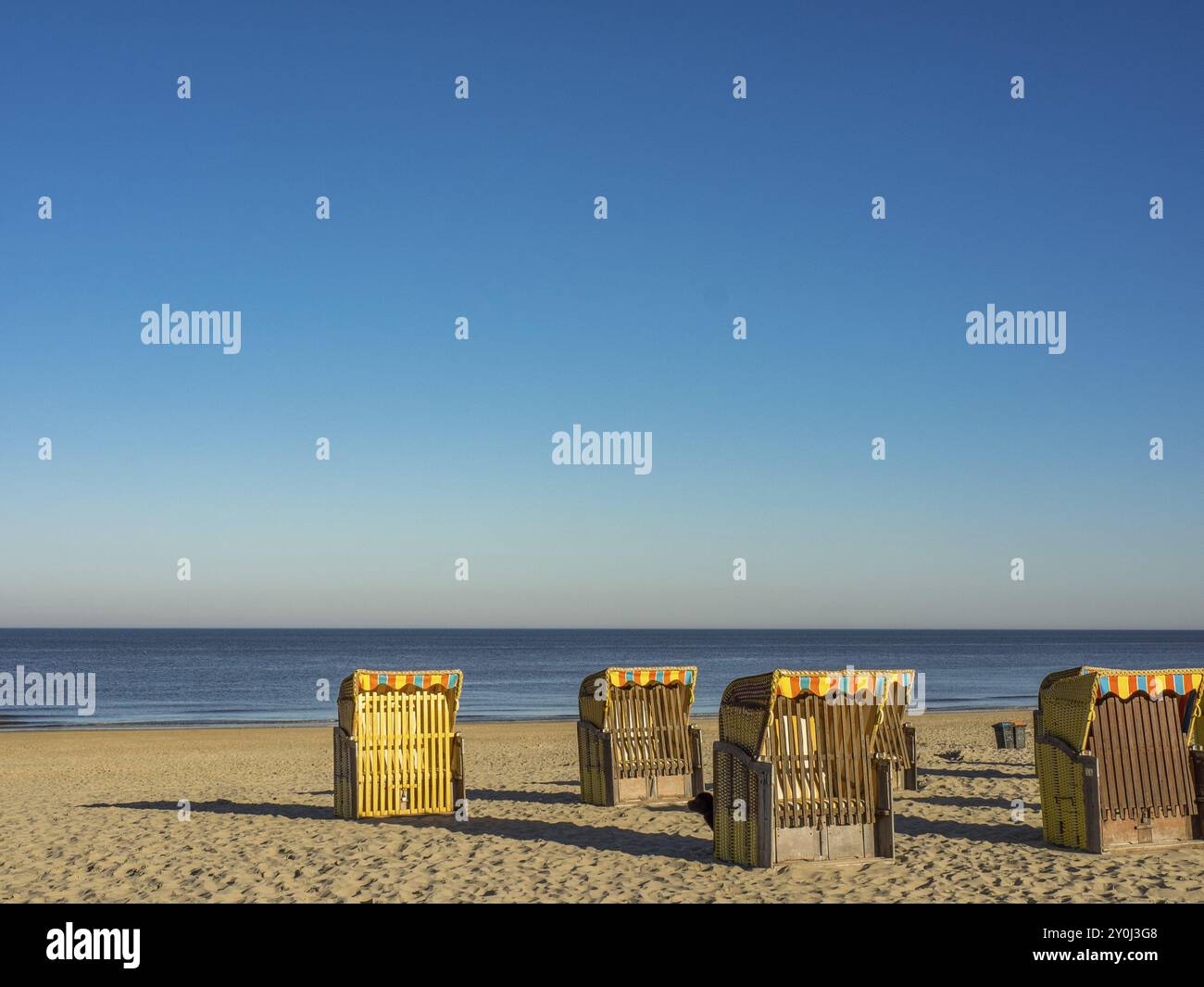 Beach with several beach chairs facing the sand, overlooking the calm ...