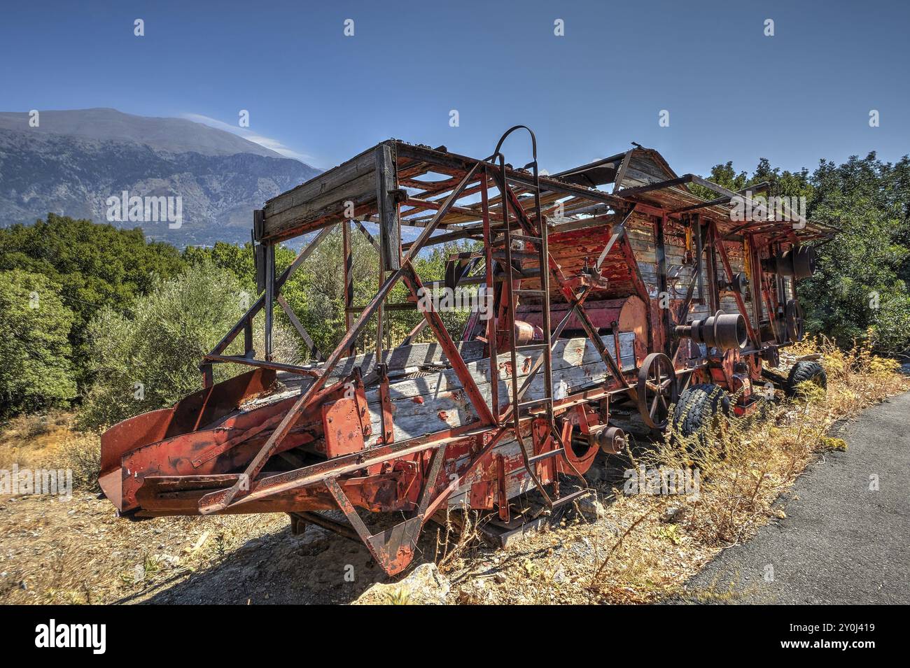 Old, rusty combine harvester in mountainous landscape with clear sky ...
