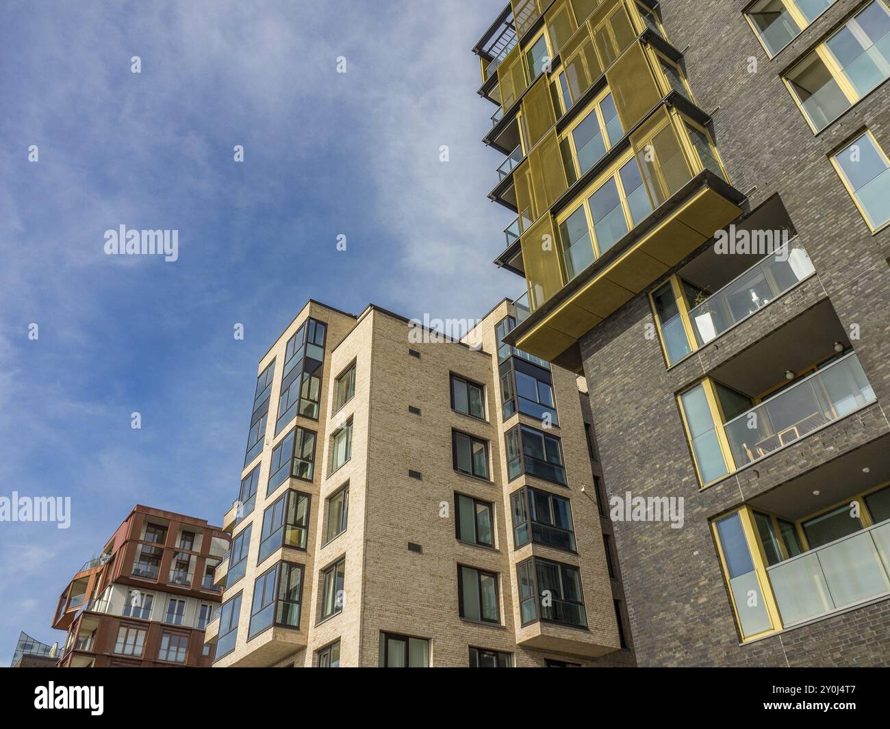 Tall, modern buildings with different facades and windows, blue sky ...