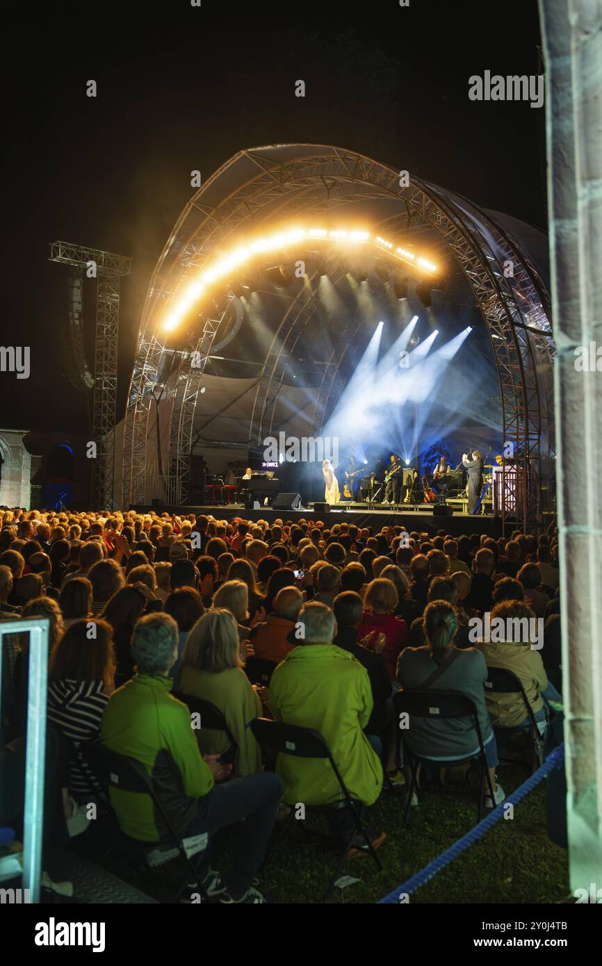 Evening open-air concert with a large crowd, illuminated stage and ...