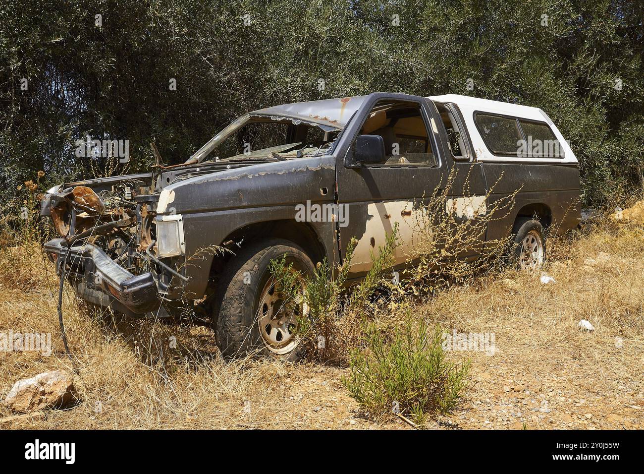 Abandoned rusted car with worn paint in a shady wooded area, wrecked ...