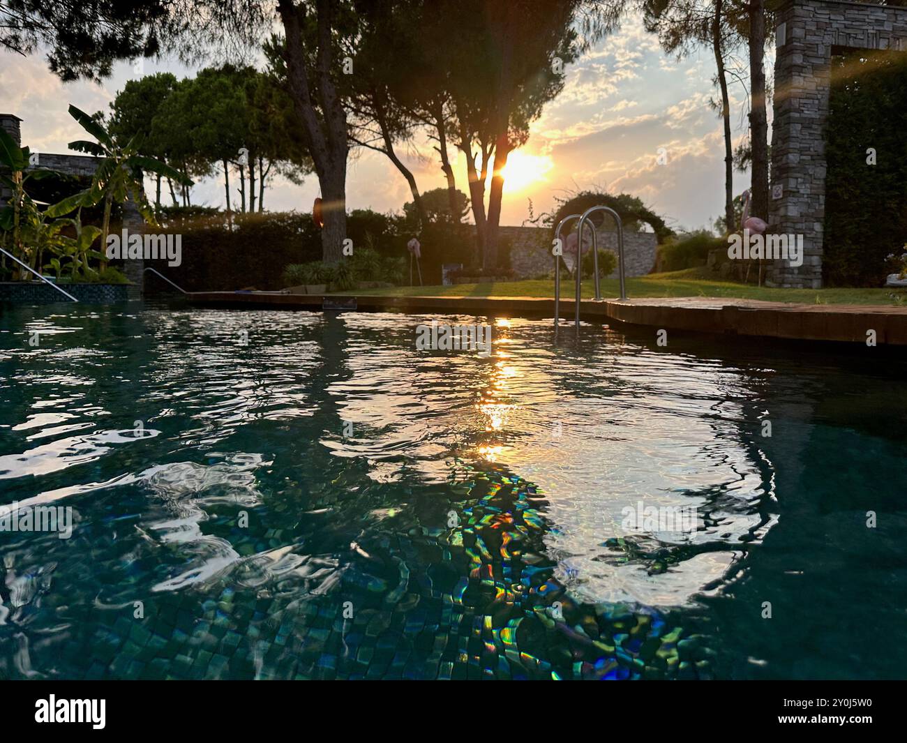 Outdoor swimming pool with clear water at sunset Stock Photo - Alamy