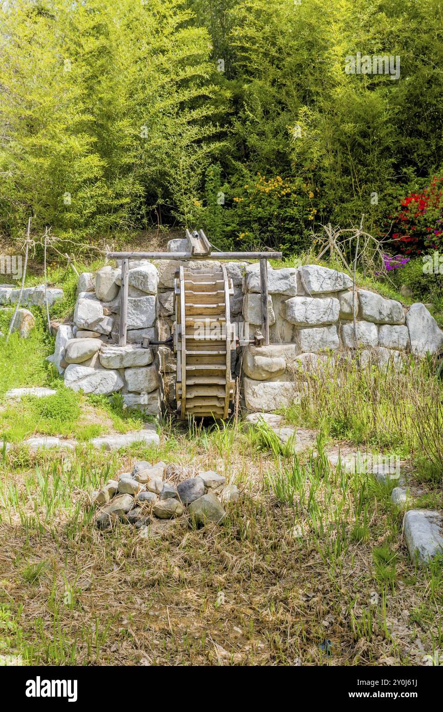 Old wooden water wheel in dried stream bed with background of colorful ...