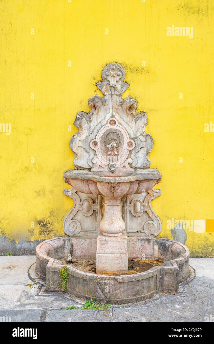 water fountain under yellow wall background, public monument belonging ...