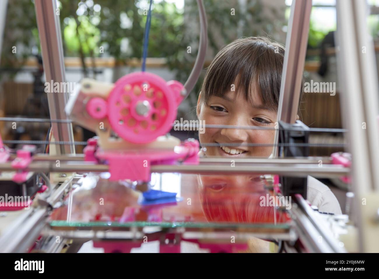 A young girl watches as a 3D printer prints an object Stock Photo - Alamy