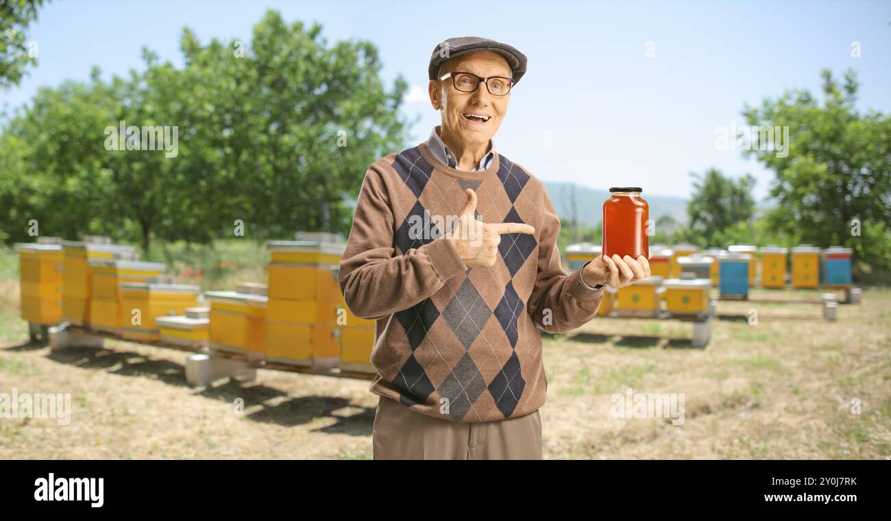 Elderly man pointing at a jar of honey at a bee farm Stock Photo - Alamy