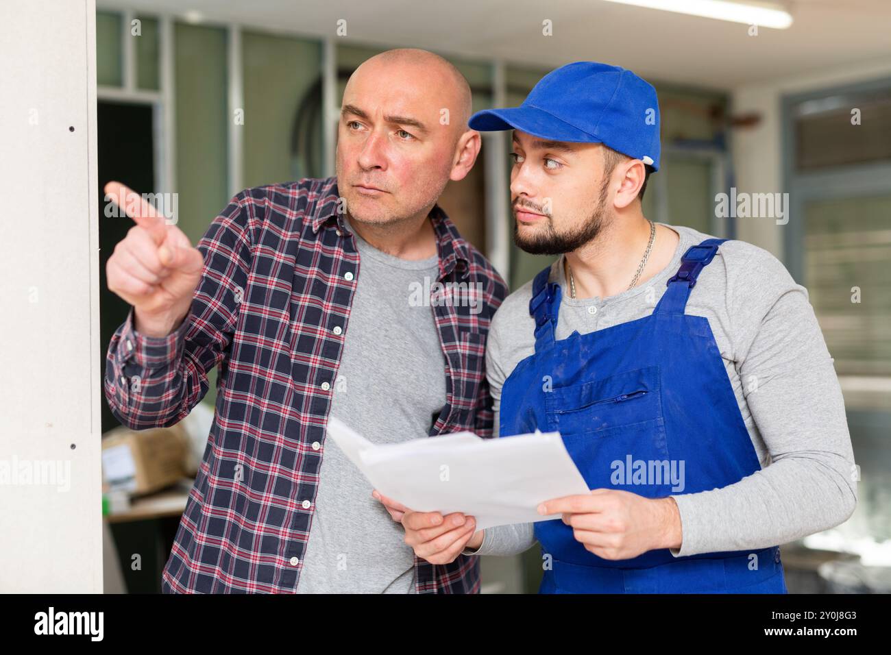Builder and owner of apartment discussing renovation works Stock Photo ...