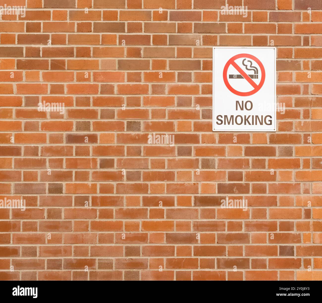 No smoking sign attached to a brick built wall expressing the ...