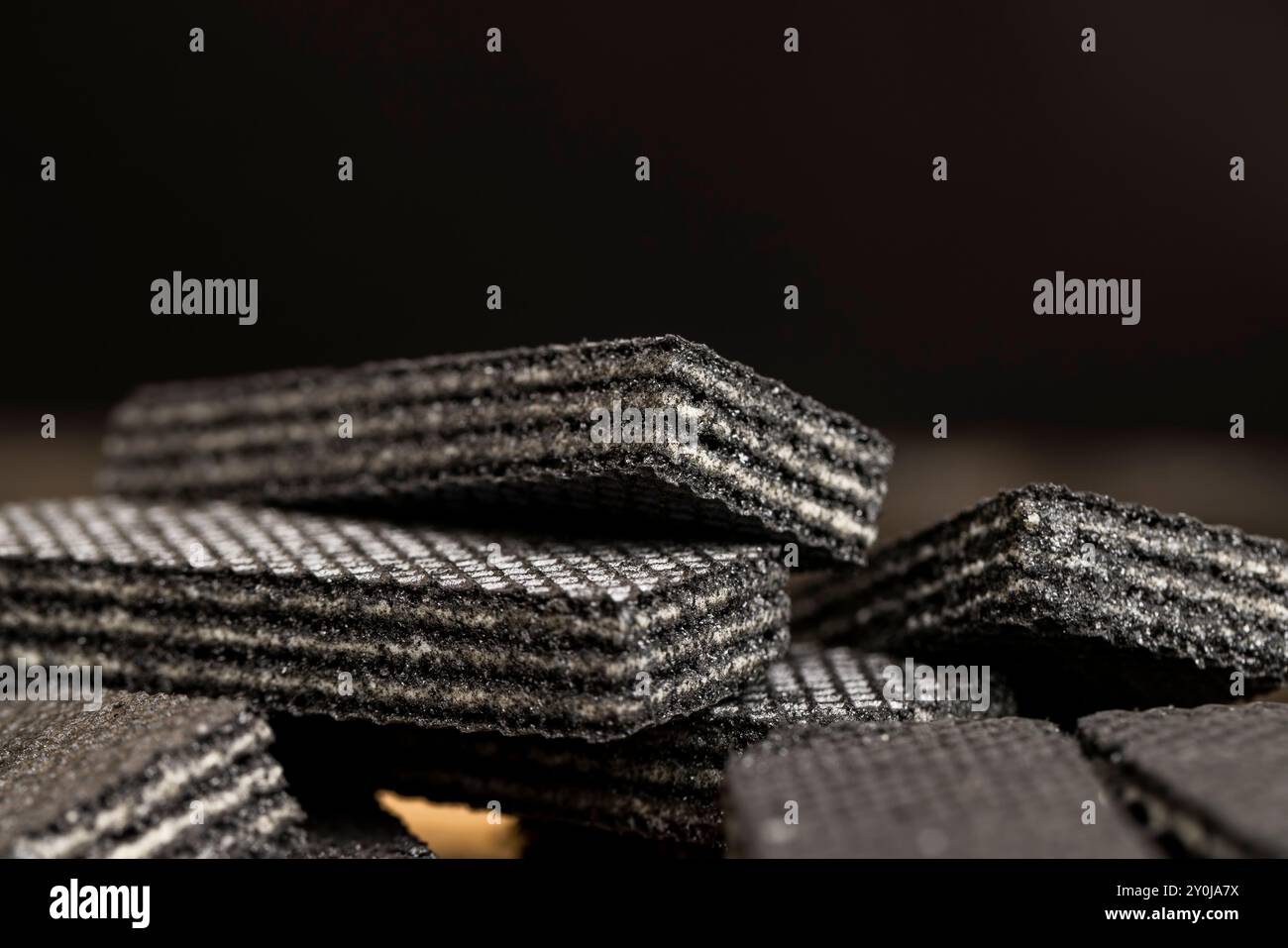 Crispy black waffles with cream filling, close-up of sweet black ...