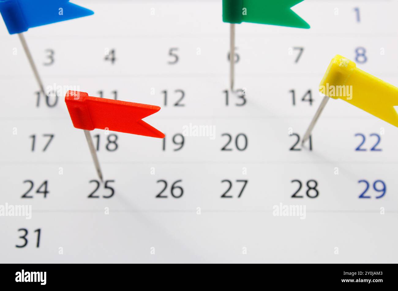 Flag shaped thumbtacks marking various days of the month Stock Photo ...
