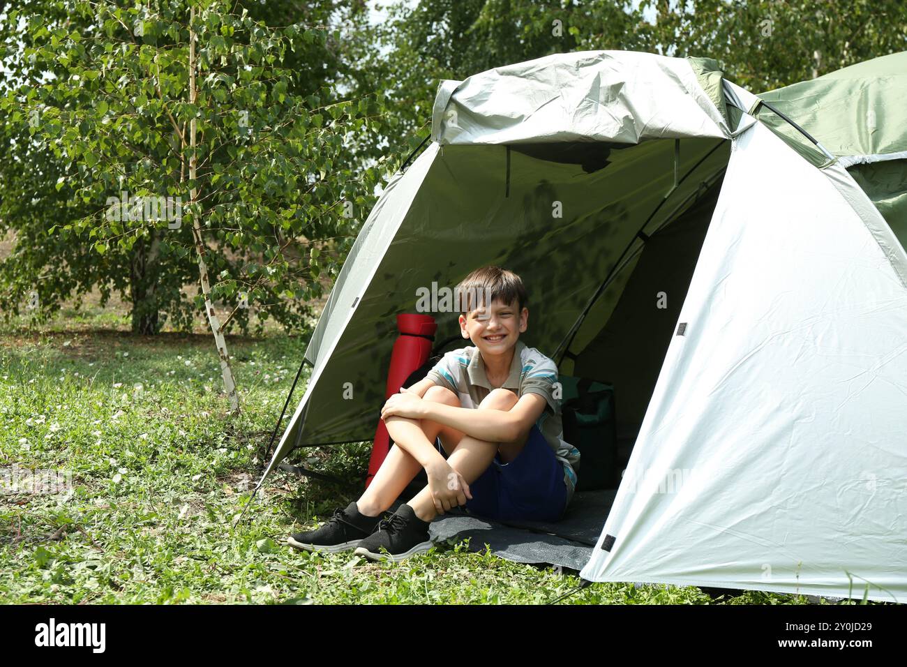 Cute boy sitting in camping tent outdoors Stock Photo - Alamy