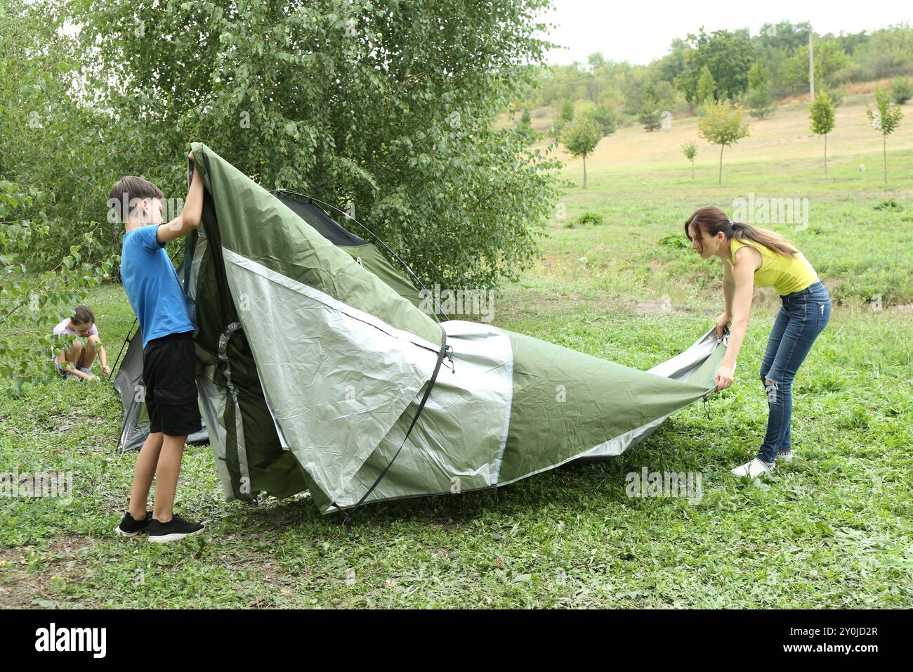 Mother and her kids setting up camping tent outdoors Stock Photo - Alamy