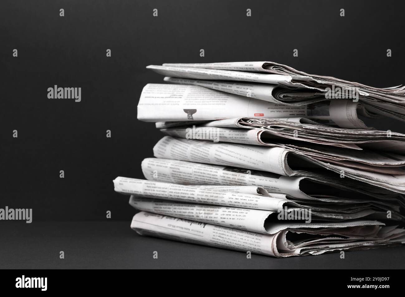 Stack of newspapers in different languages on black background Stock ...