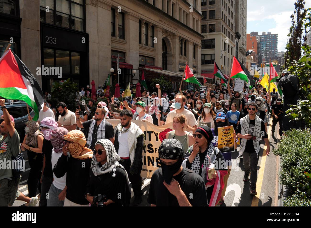 Pro-Palestine demonstrators march holding banners and waving ...