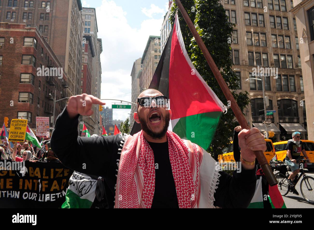 Pro-Palestine demonstrators march holding banners and waving ...