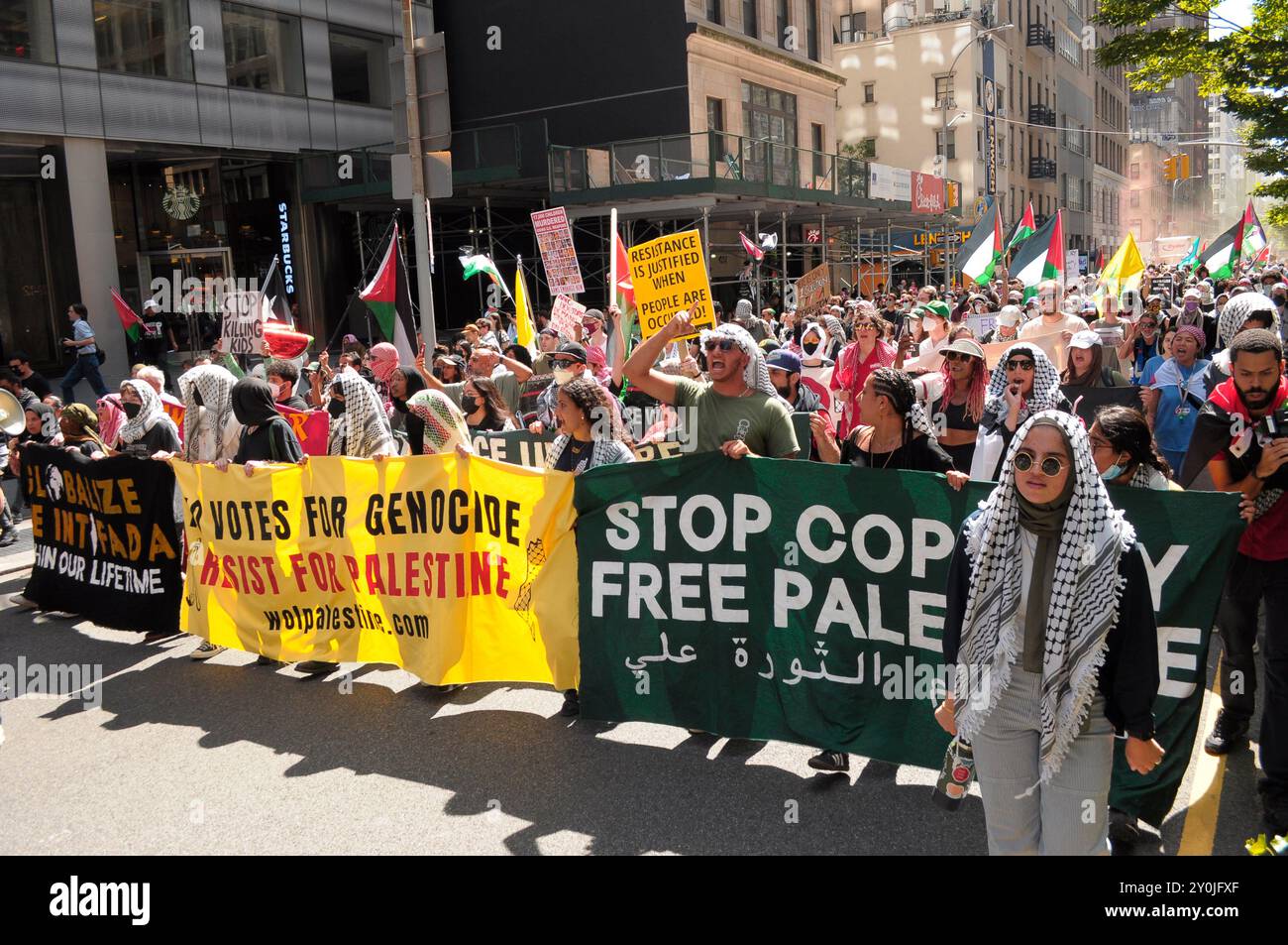 Pro-Palestine demonstrators march holding banners and waving ...