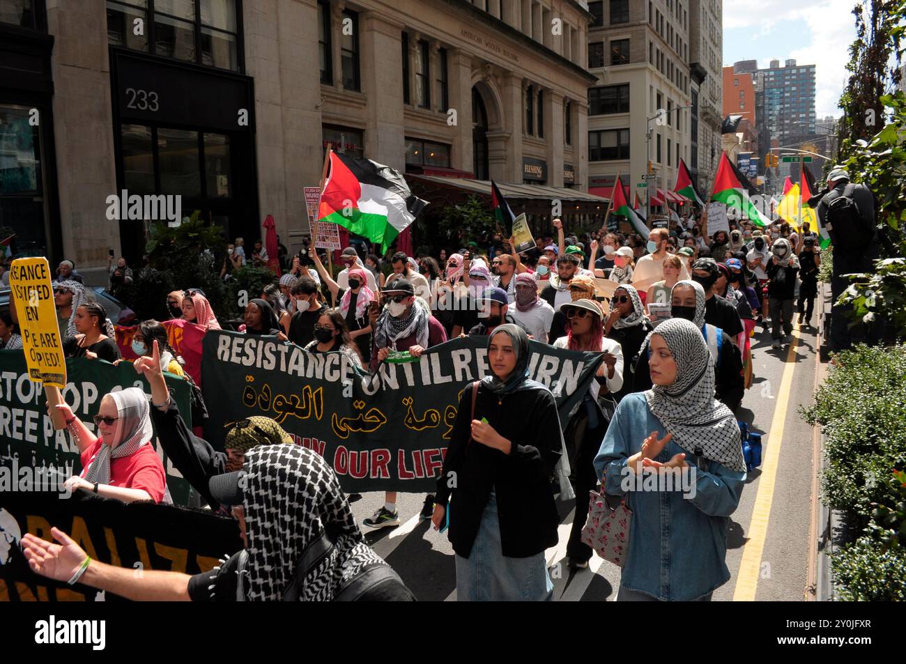 Pro-Palestine demonstrators march holding banners and waving ...