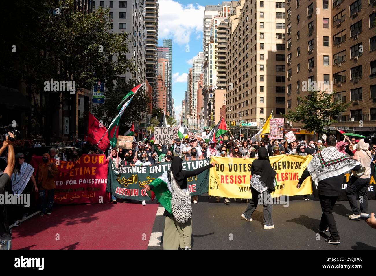 Pro-Palestine demonstrators march holding banners and waving ...