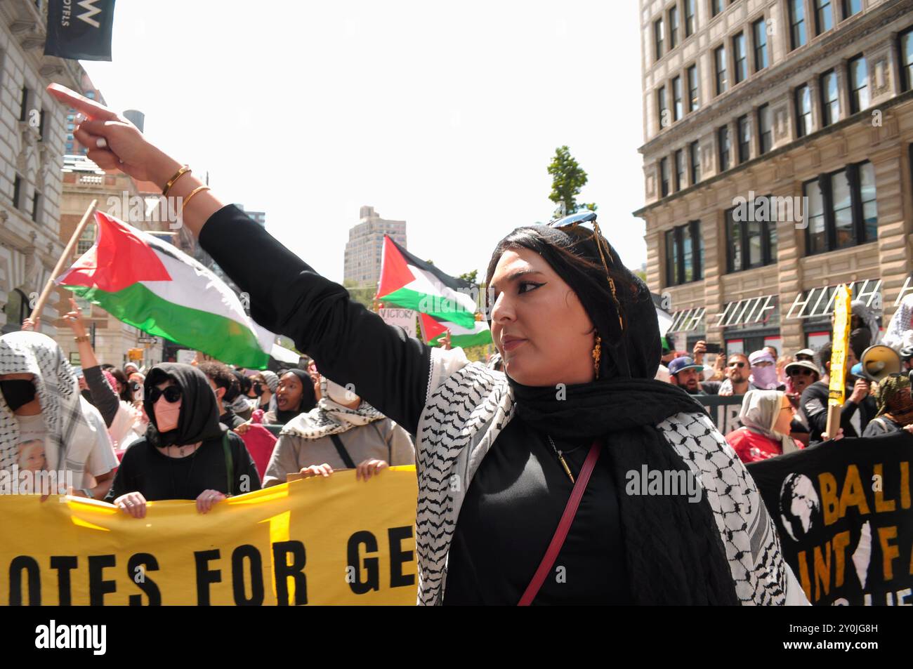 Pro-Palestine demonstrators march holding banners and waving ...