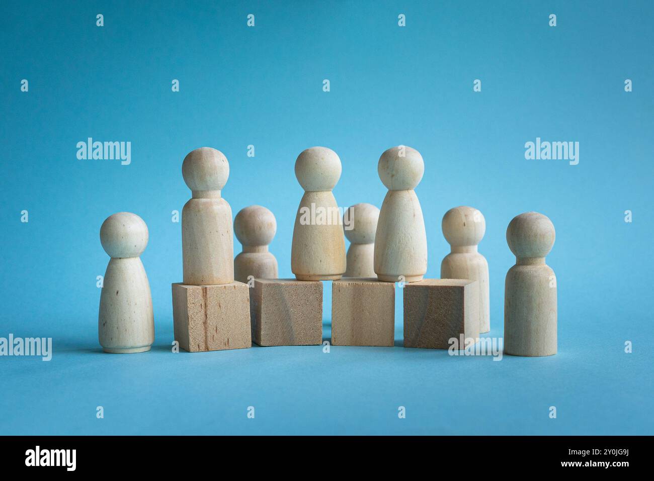 Toy blocks of people and square shape on desk, blue background ...