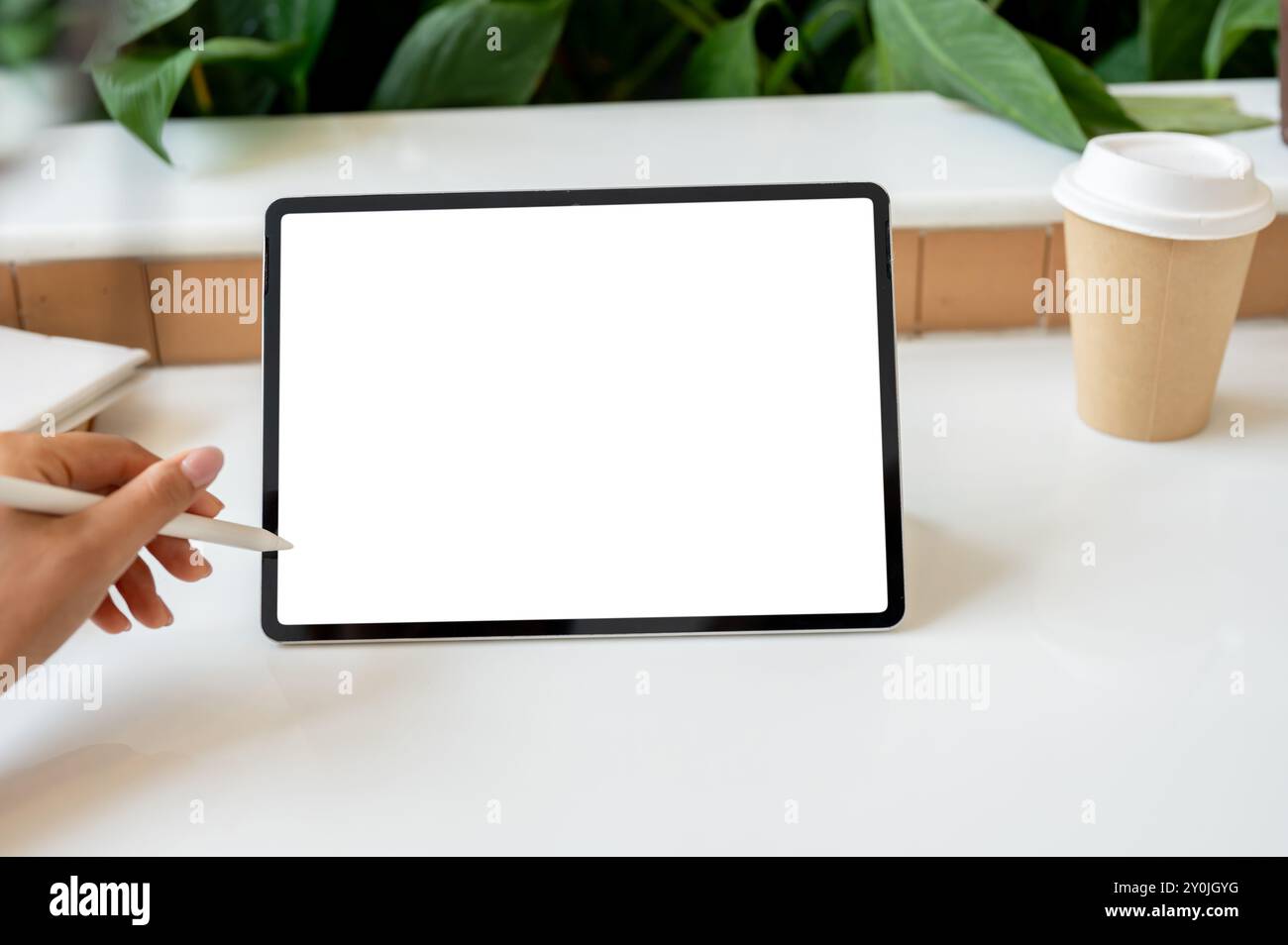 A close-up image of a woman working remotely from a coffee shop, using ...