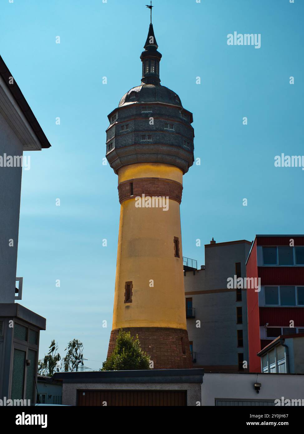 A water tower with an old construction, on a clear sky with a yellow ...