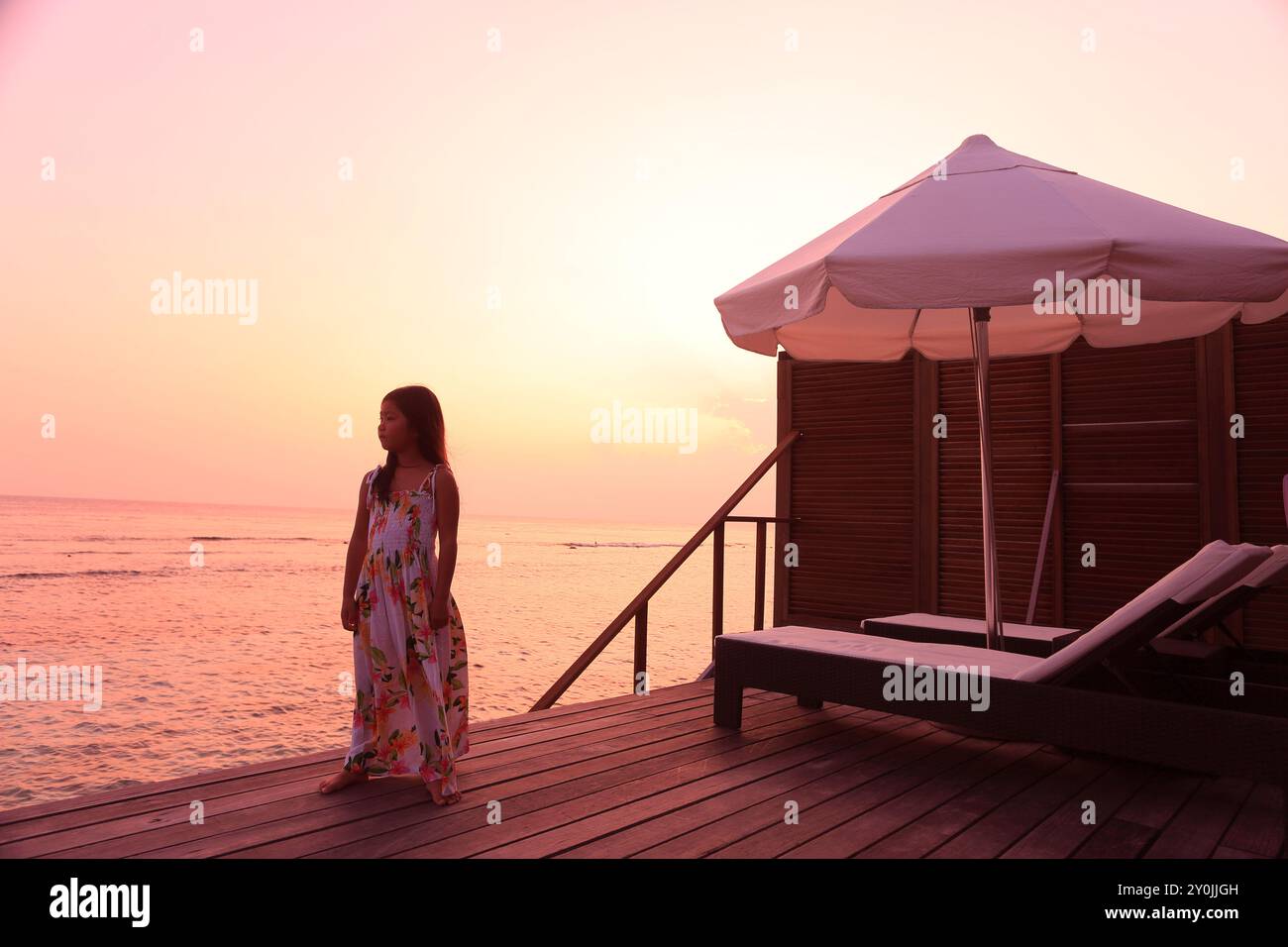 Girl looking at the sunset from a Maldives water cottage Stock Photo ...