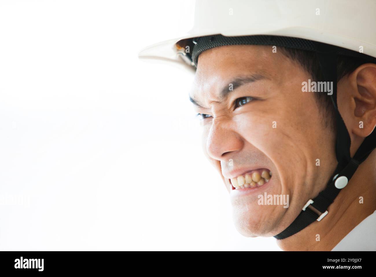 Male worker clenching his teeth Stock Photo - Alamy