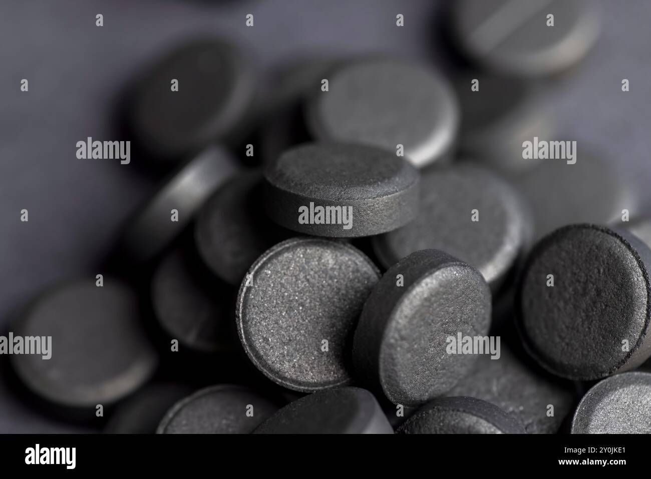 Open and unpacked tablets of black color close-up, several of the same ...