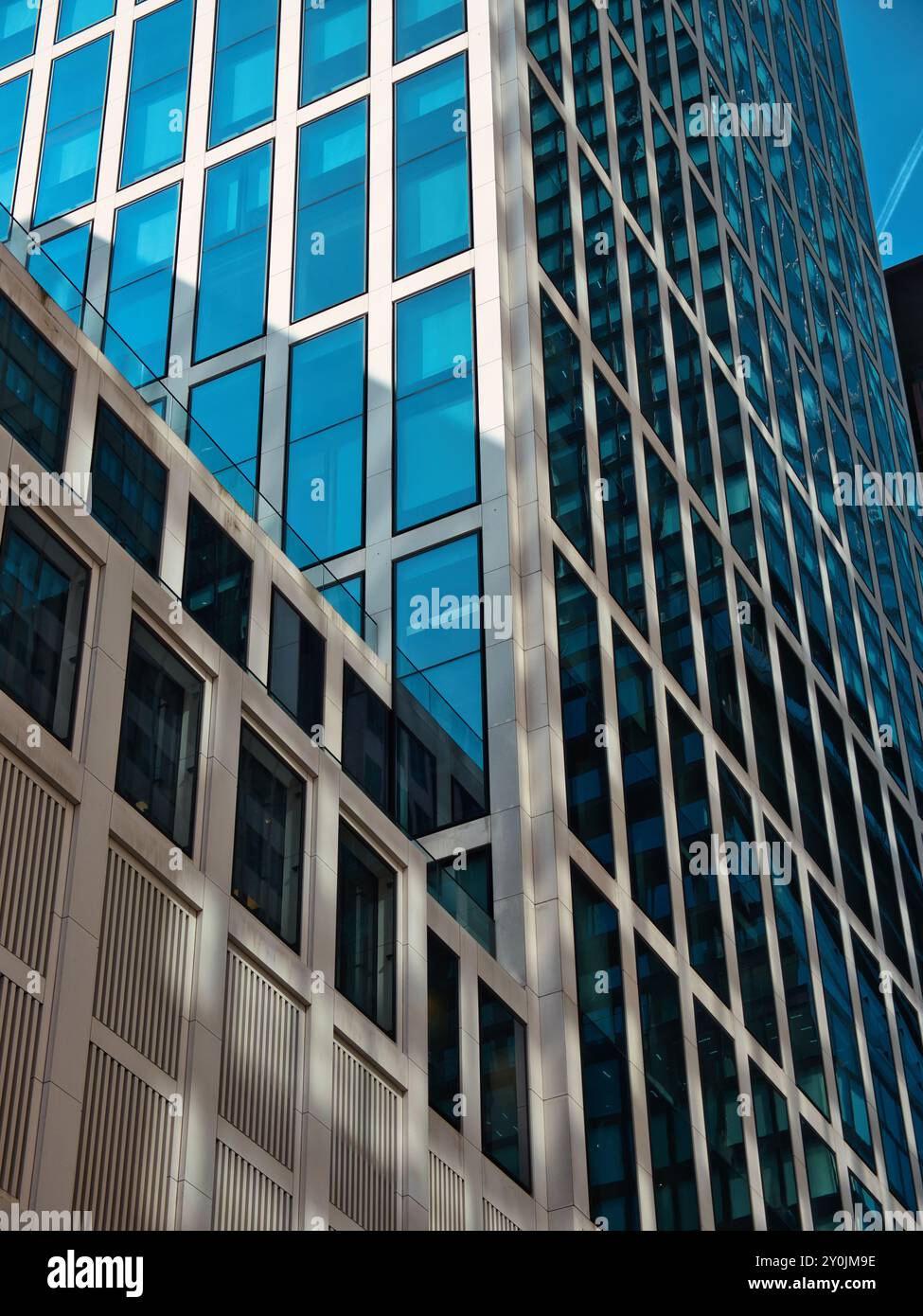 Detail of a skyscraper with white front and large glass windows with ...