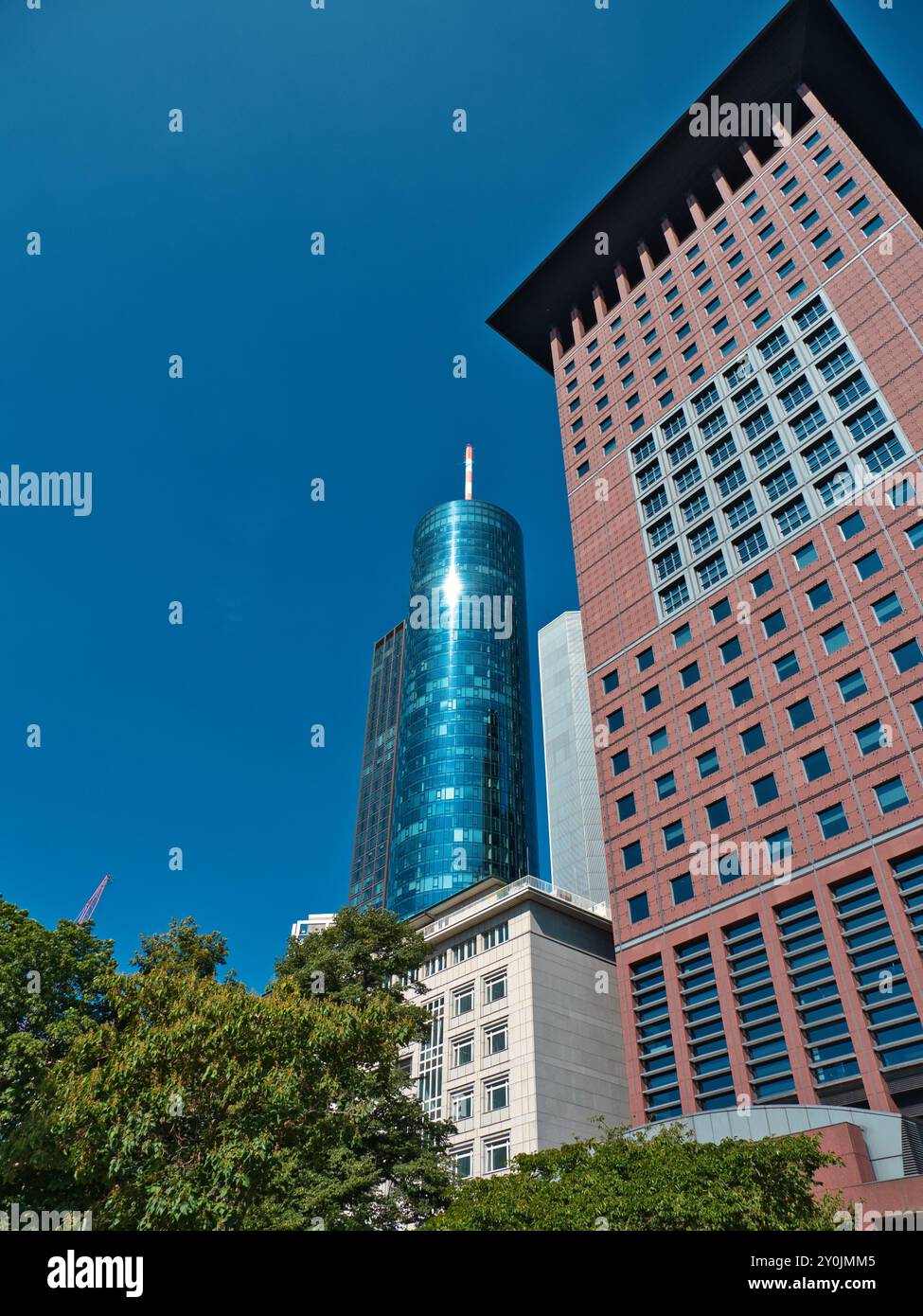 A round skyscraper with glass front and blue sky or European Central ...