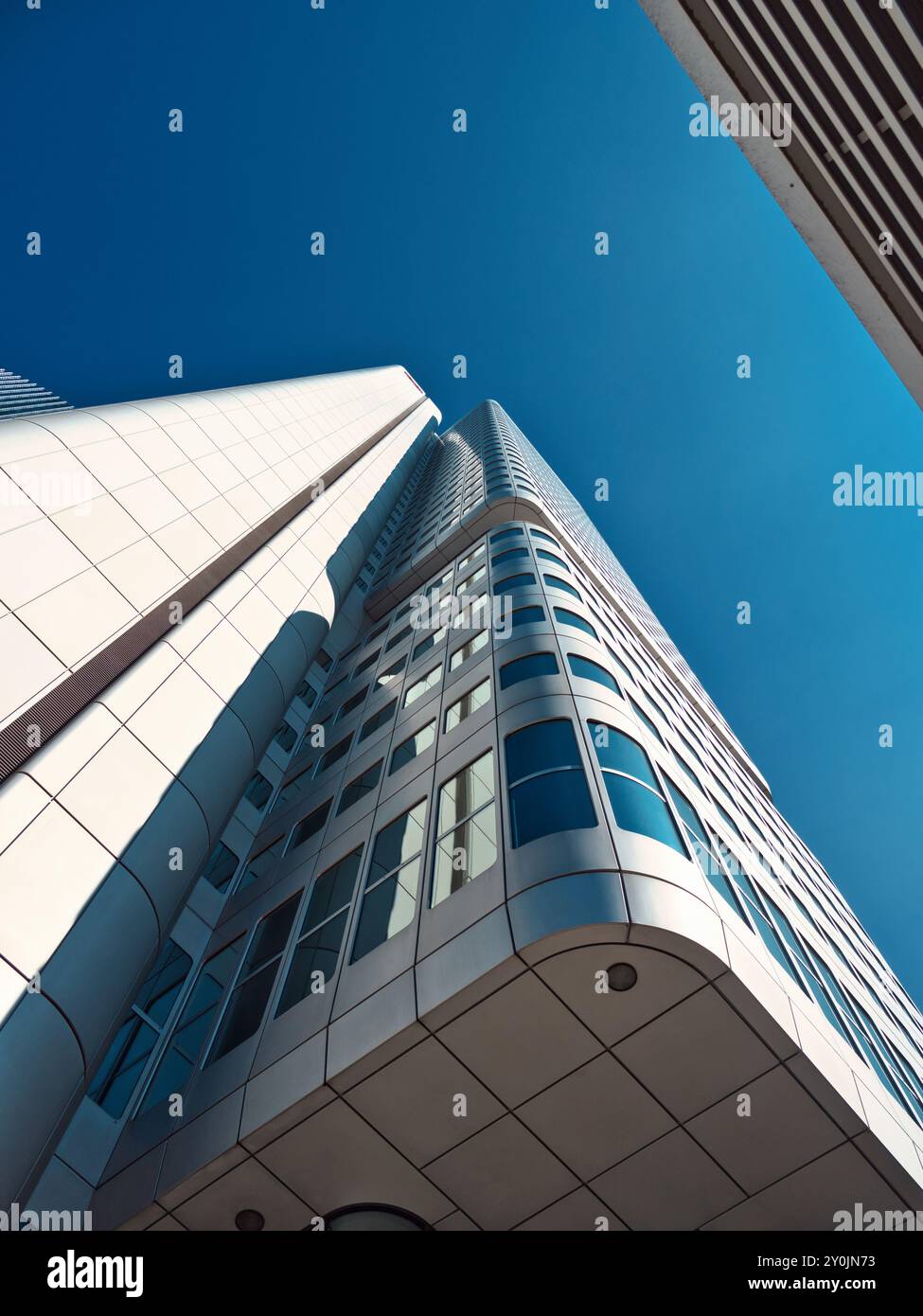A shot of a skyscraper with round architectural features taken from ...