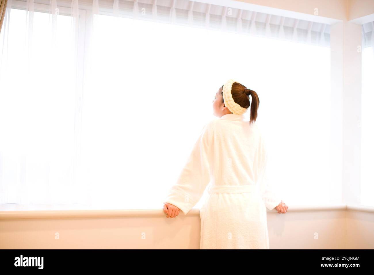 Woman standing by the window Stock Photo - Alamy