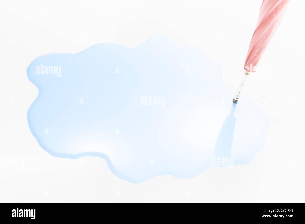Light blue puddle and a pink umbrella Stock Photo - Alamy