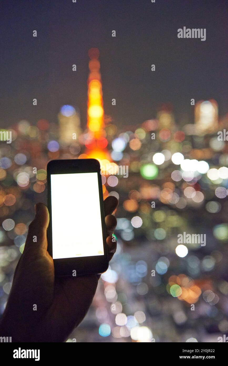 Night view of Tokyo and a smart phone Stock Photo - Alamy