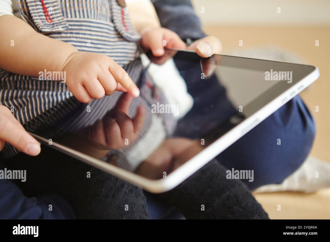 Girl looking at tablet with mom Stock Photo - Alamy